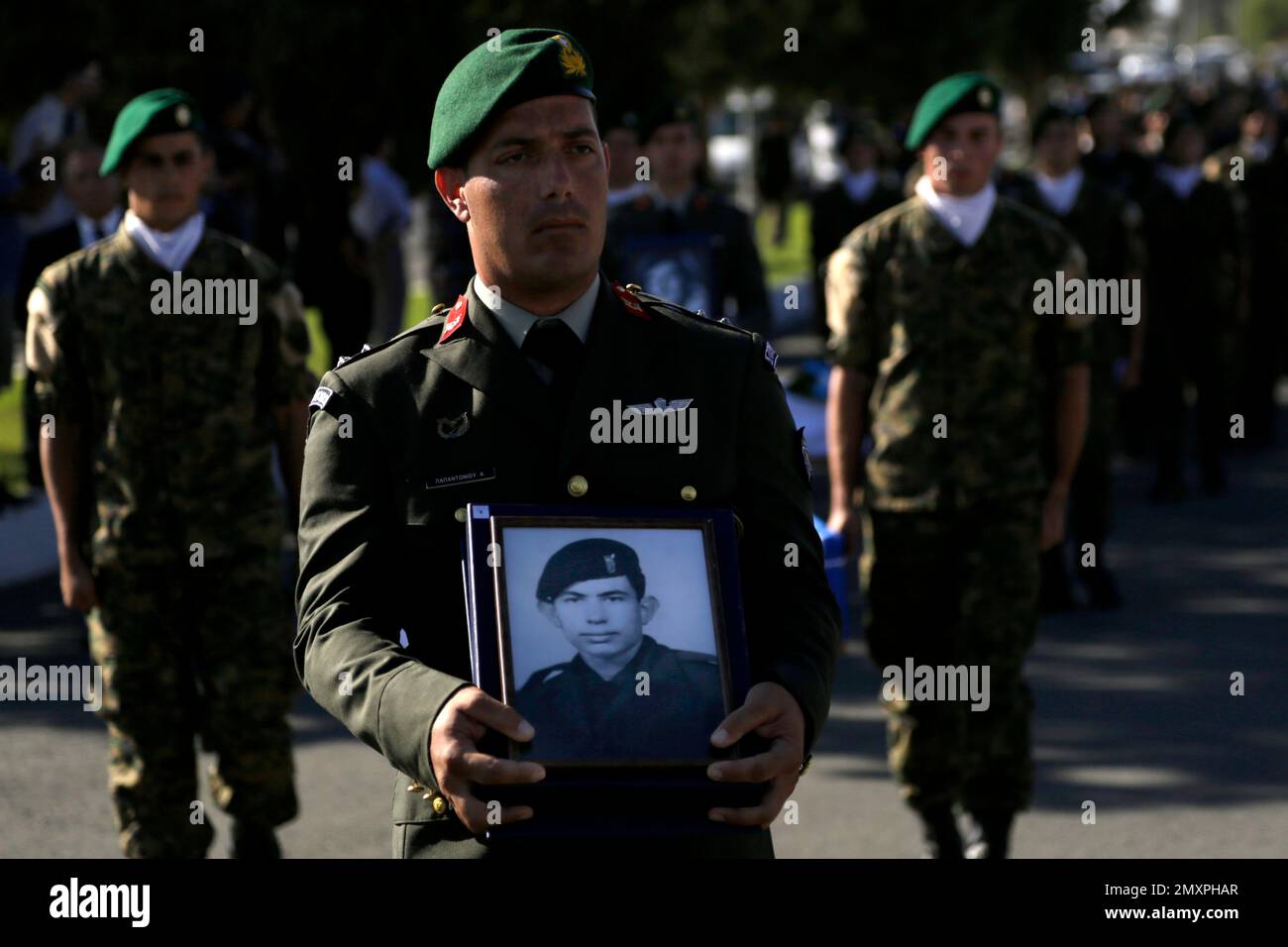 Greek soldiers carry the coffins and the photographs of the Greek ...