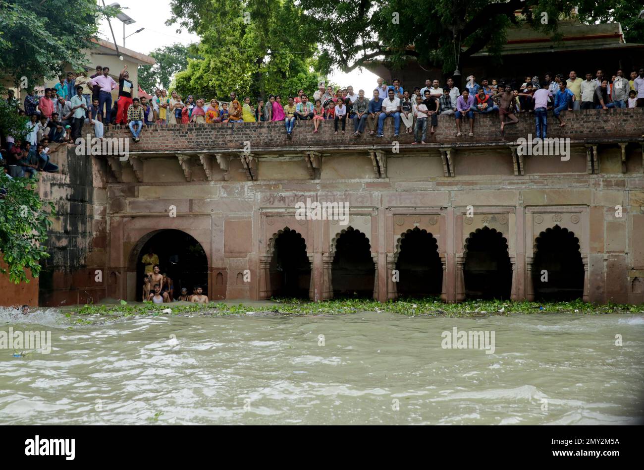 Indians look at the flooded river Ganges from the top of a Hindu temple ...