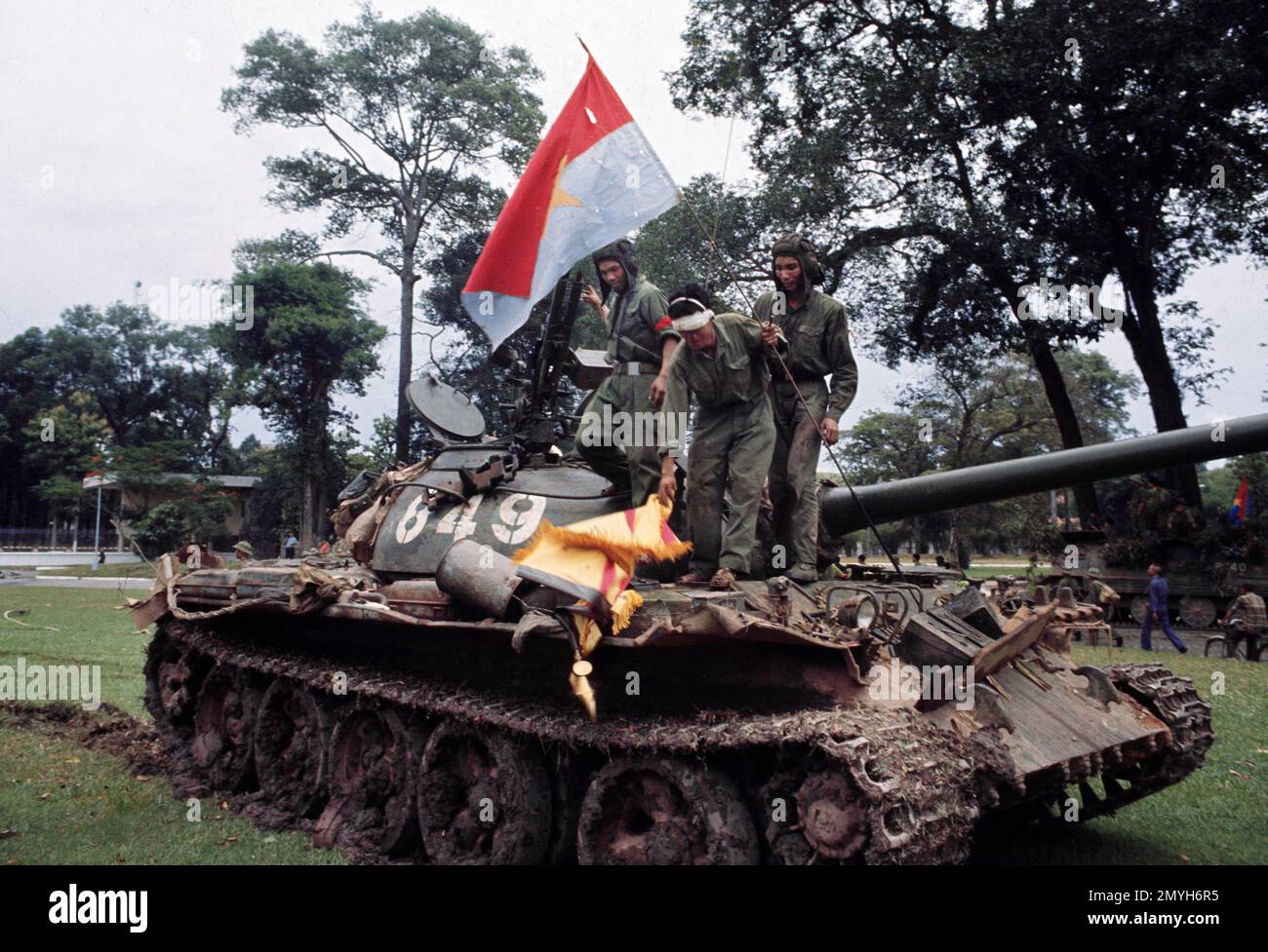 Victorious North Vietnamese soldiers display a communist flag as they ...