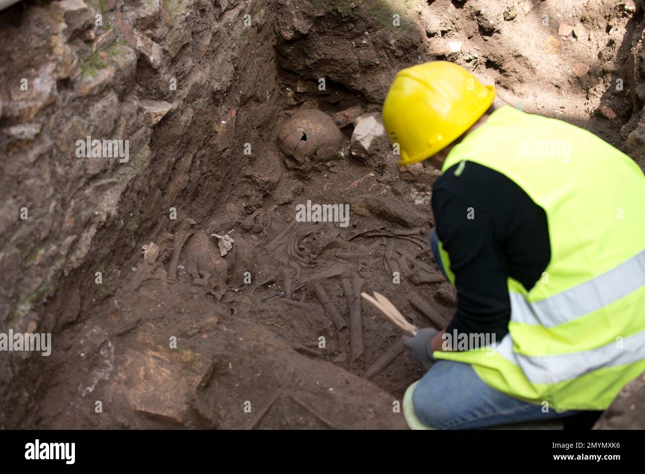 An archeologist checks human bones as ancient roman ruins of former ...