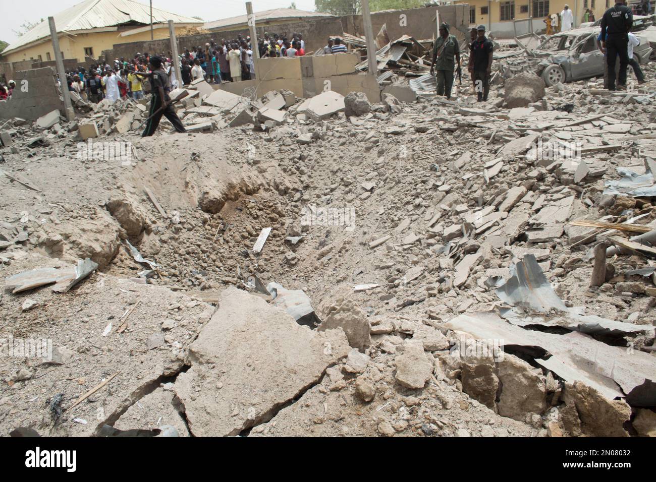 Nigerian police officers stand around a crater following an accidental ...