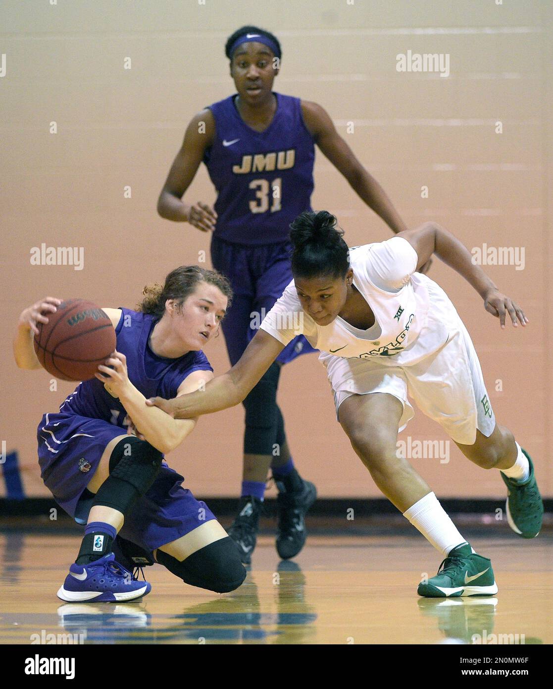 James Madison guard Logan Reynolds, left, and Baylor guard Niya Johnson ...