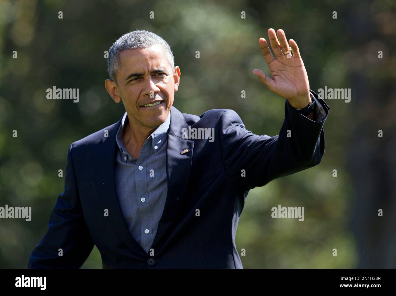 President Barack Obama waves as he walks on the South Lawn of the White ...