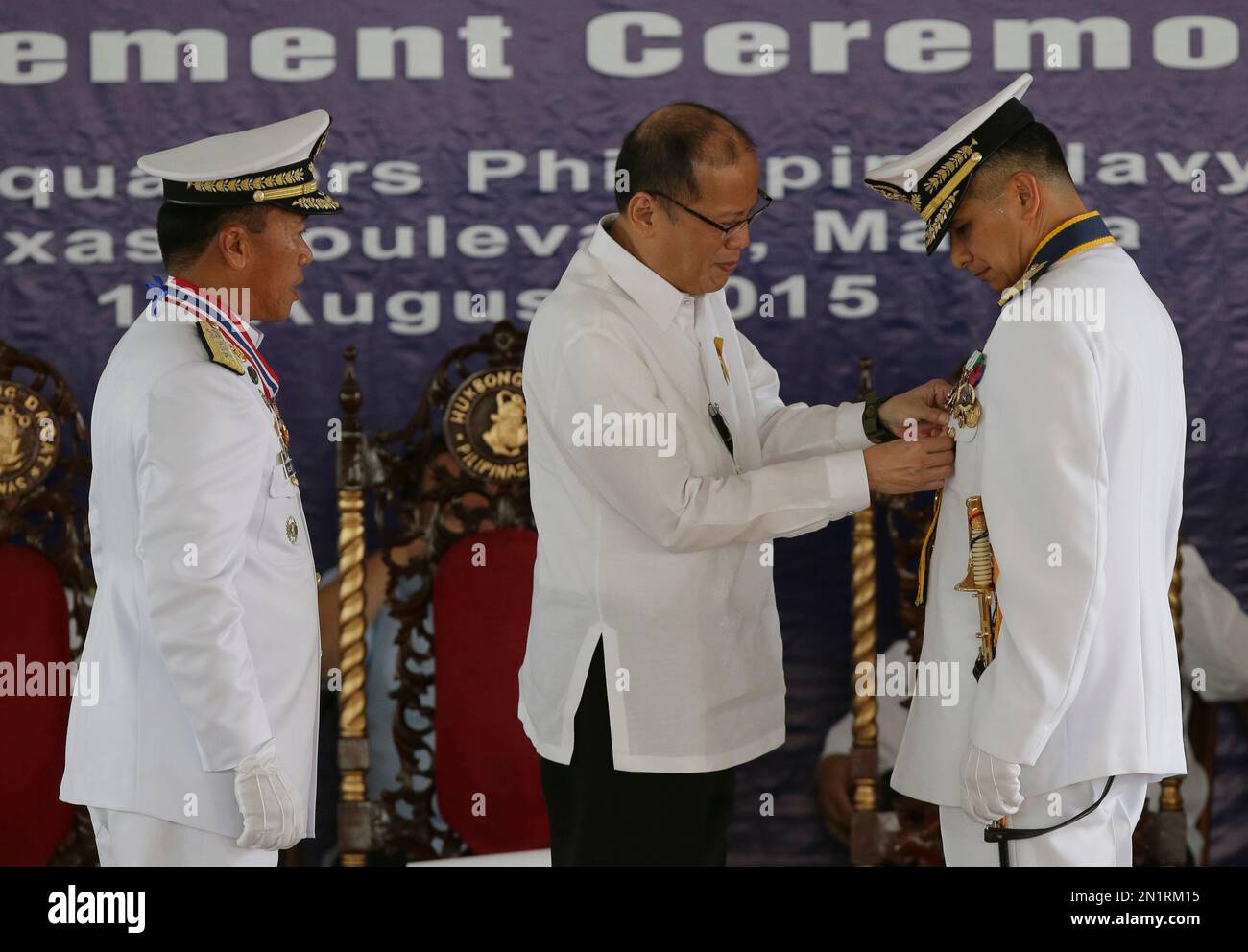Philippine President Benigno Aquino III, center, places a pin on new ...