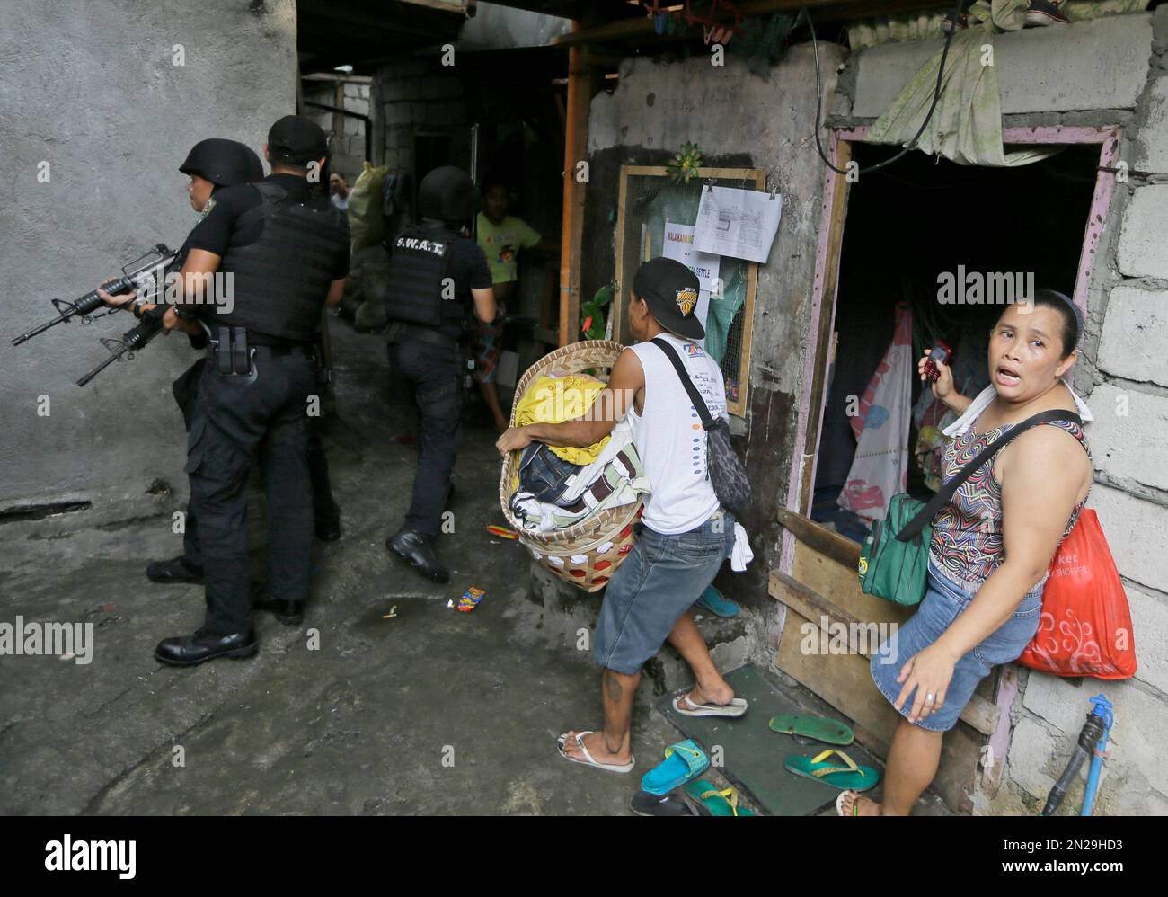Members of the Philippine National Police conduct a house-to-house ...