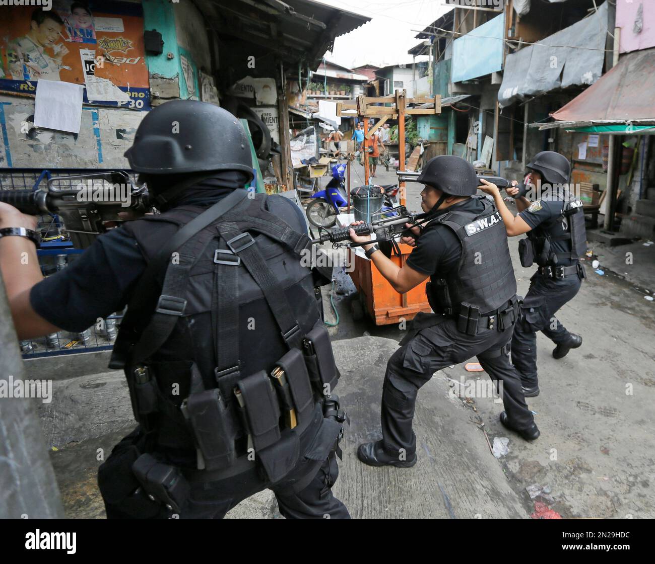 Members of the Philippine National Police conduct a house-to-house ...