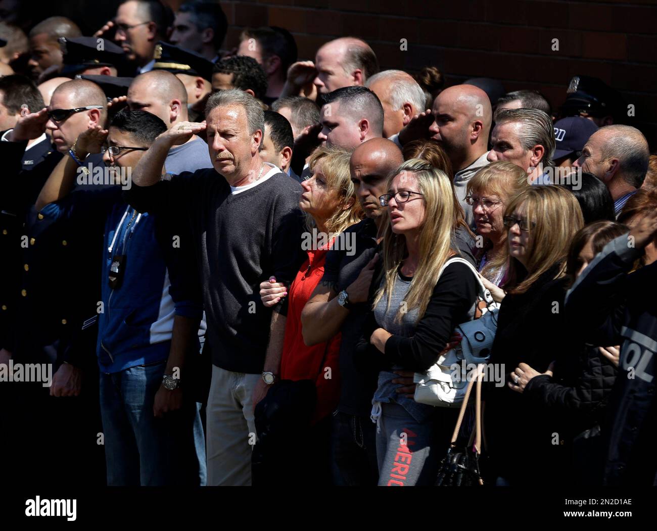 Raymond Moore, father of Brian Moore, third from left, salutes as the ...