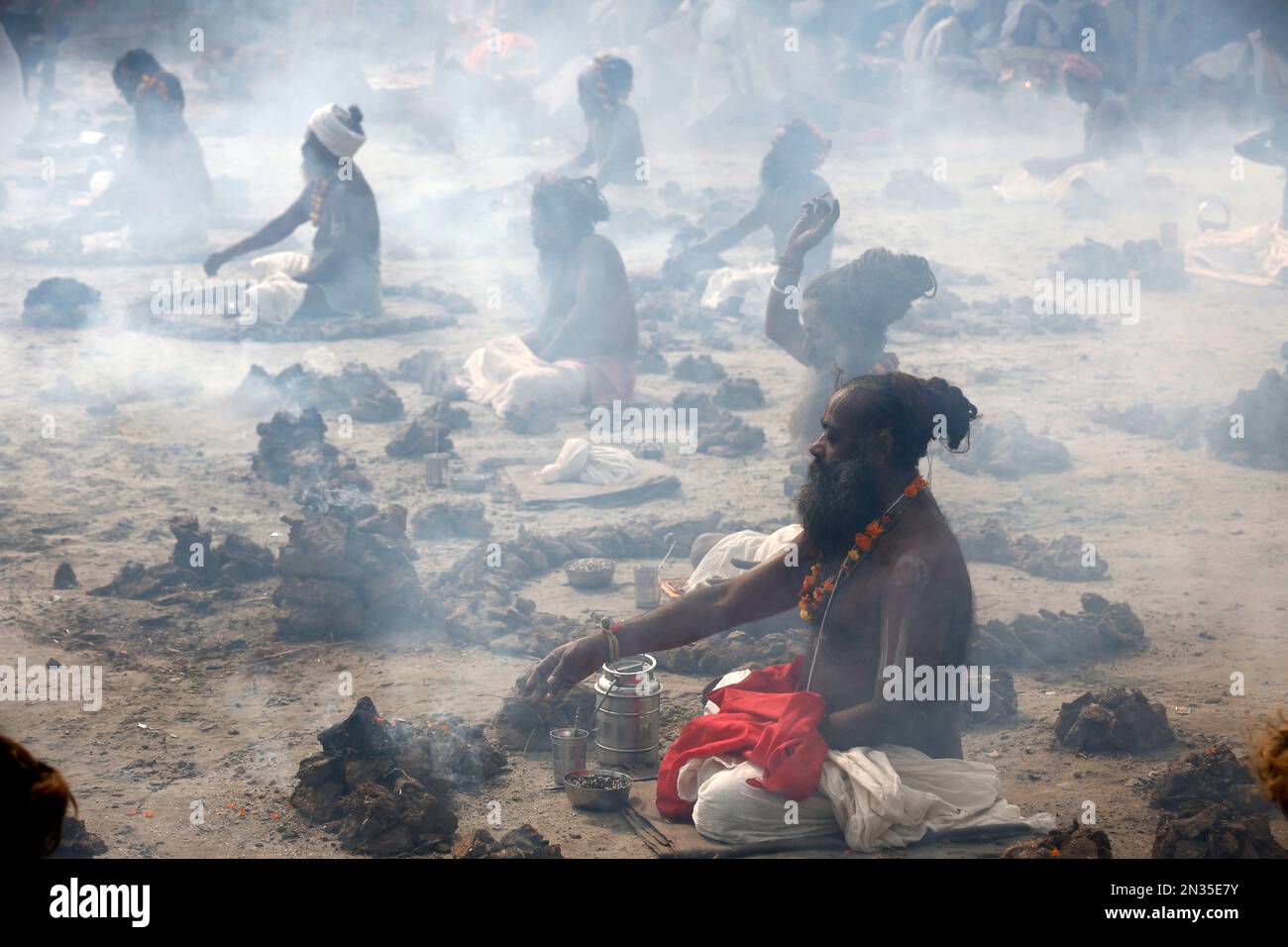 Indian Sadhu, or Hindu holy men, perform a ritual by burning dried cow ...