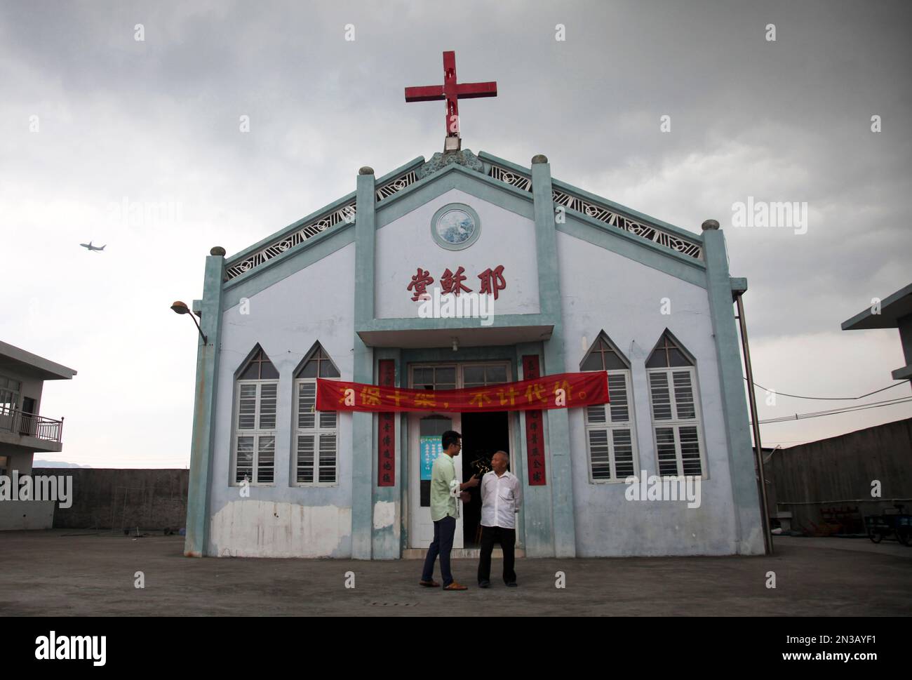In this photo taken July 15, 2014, Pastor Tao Chongyin, left, speaks ...