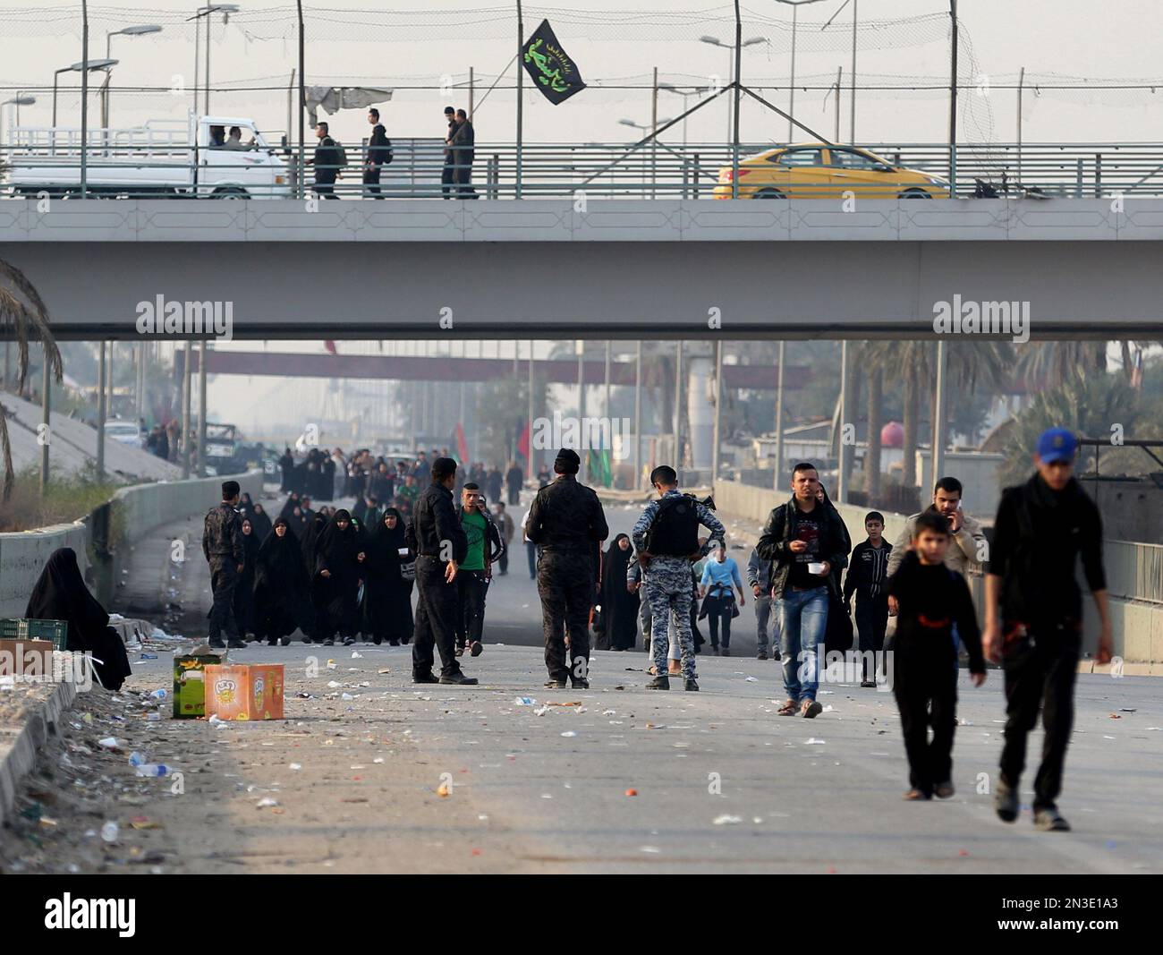 Iraqi security forces stand guard while Shiite faithful pilgrims march ...