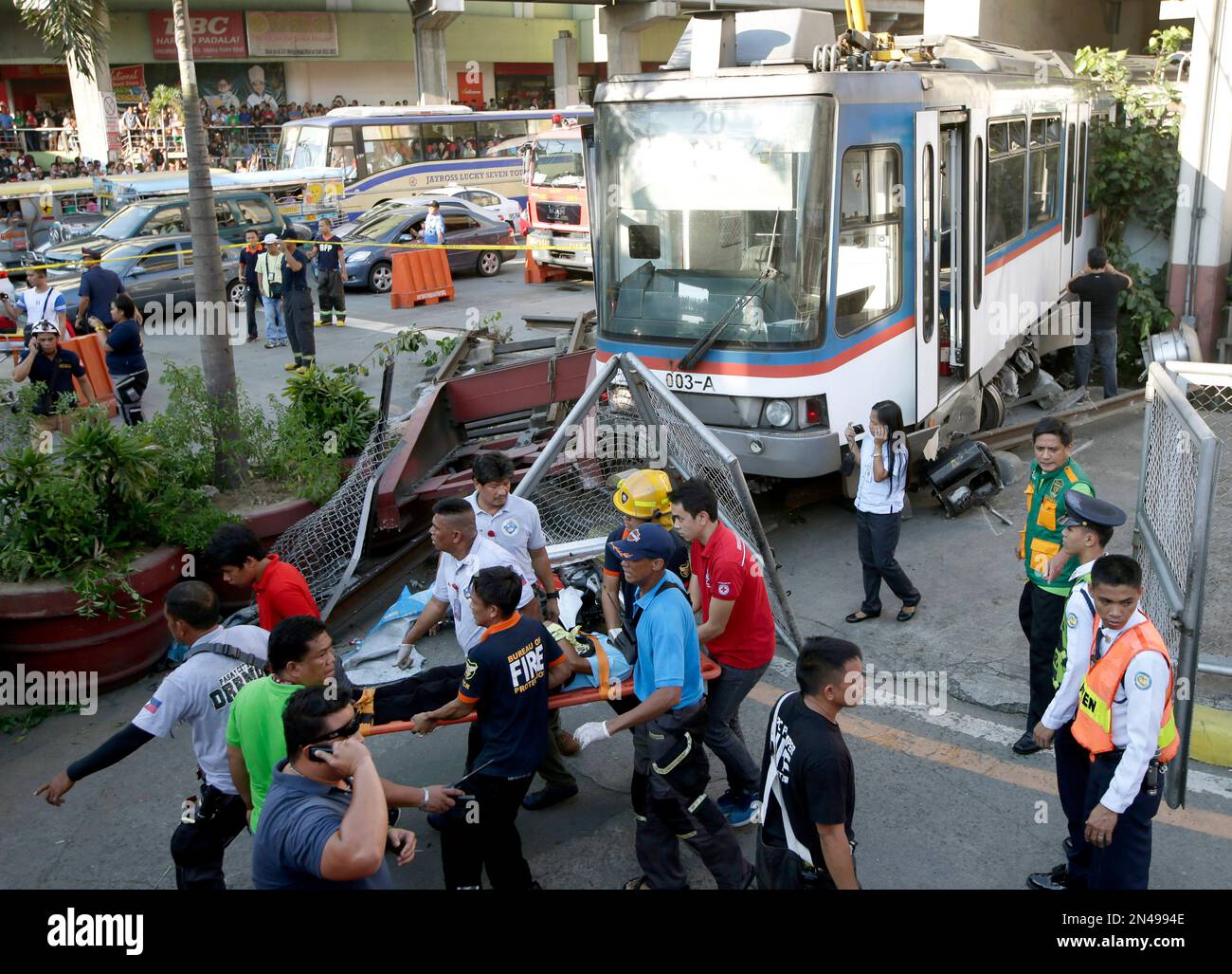 Rescuers rush an injured passenger to a hospital after an elevated commuter train known as Metro ...