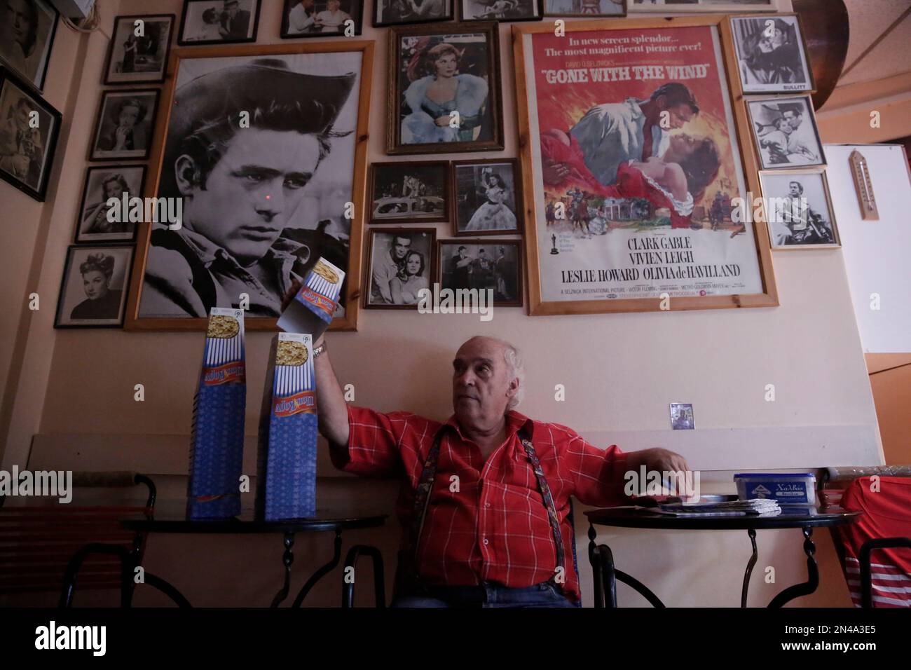 In this July 23, 2014 photo, a man stacks popcorn boxes beside movie ...
