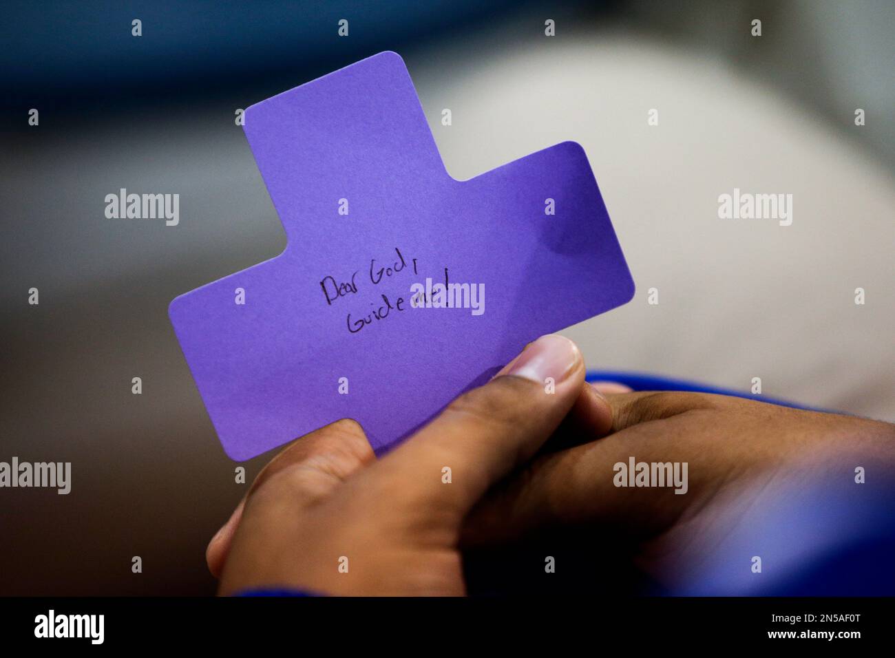 Randall Swain, 18, holds a paper cross before an Ash Wednesday Mass at ...