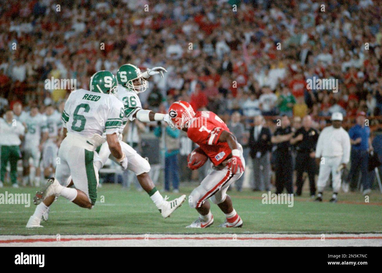 Georgia's Rodney Hampton (7) is grabbed in his face mask by Michigan ...