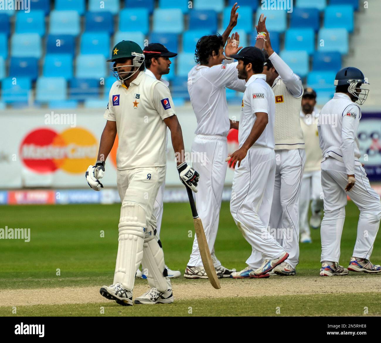 Rahat Ali of Pakistan, left, leaves the pitch after being caught by ...