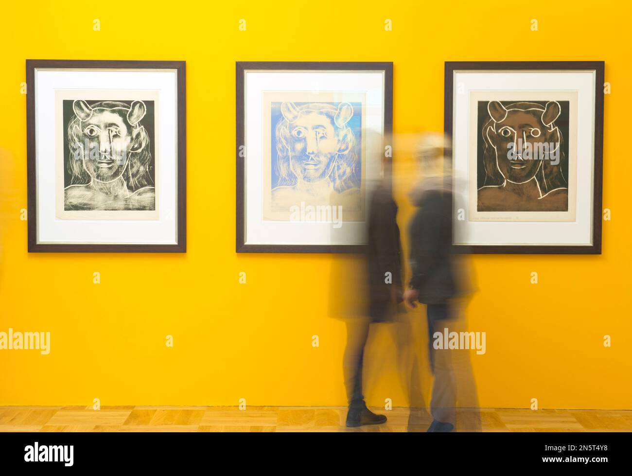 People walk in front of the lithographs 'Faunskopf' (Head of Faun) 1962 ...