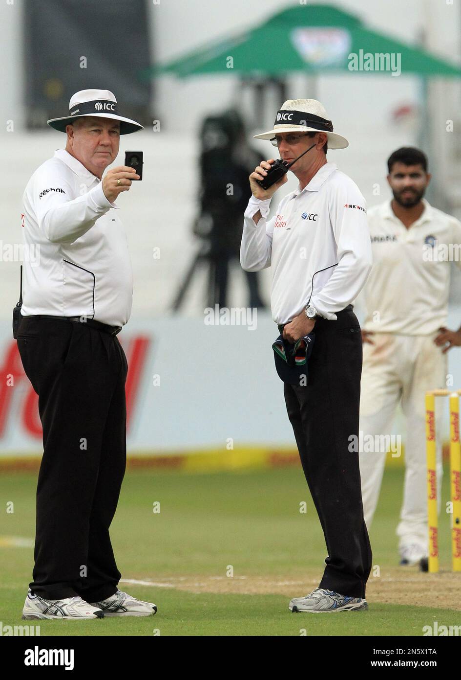 Umpire Steve Davis, left, checks the light reading with a light meter ...