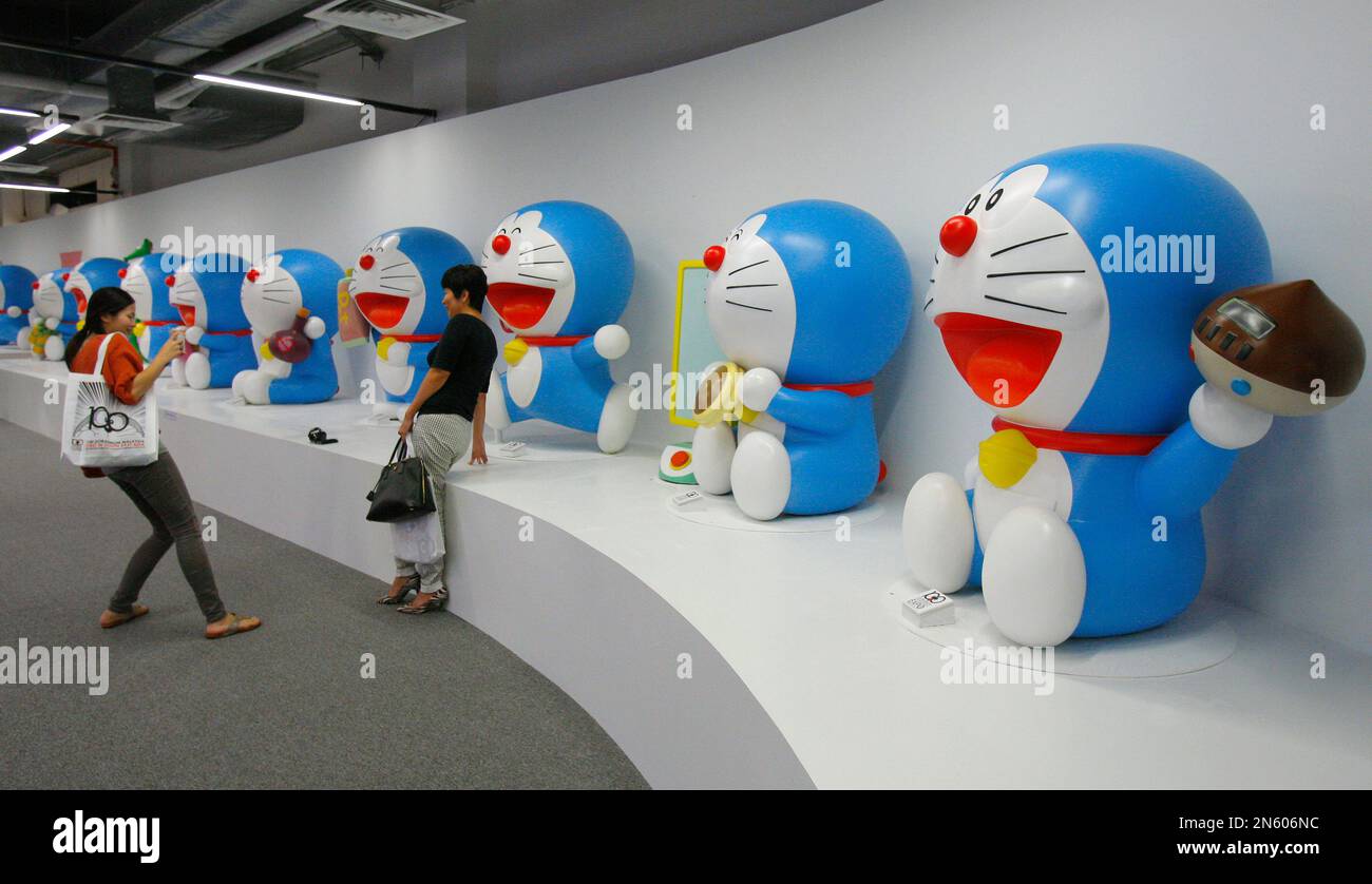 Visitors take a photo with models of Doraemon, one of Japan's most ...
