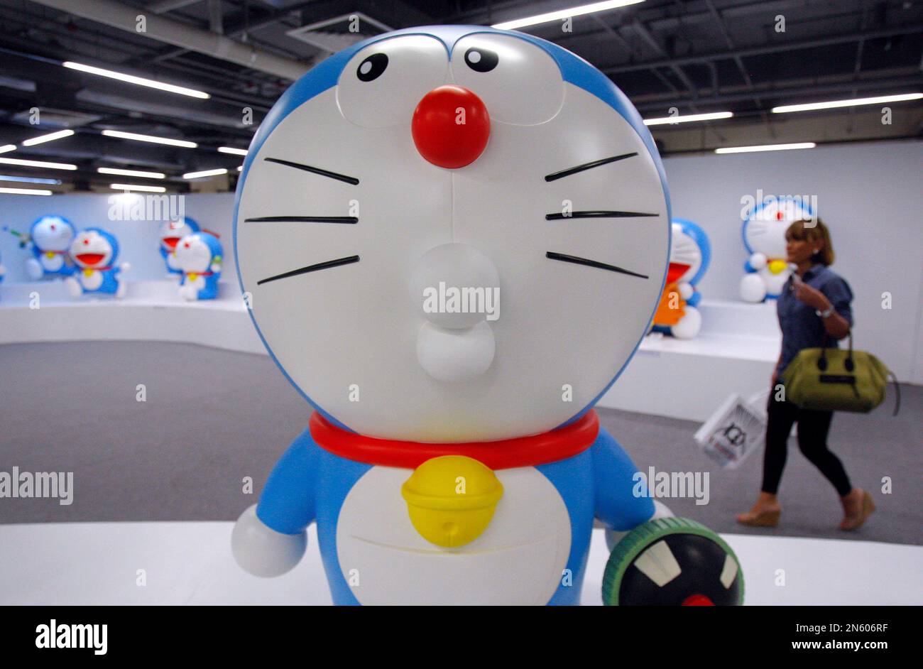 A visitor walks past models of Doraemon, one of Japan's most popular ...