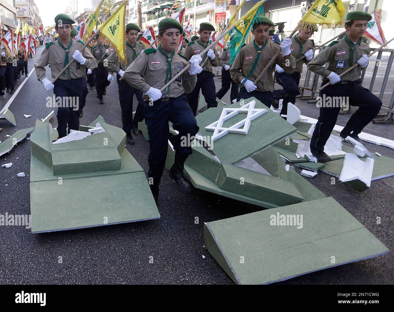 Hezbollah al-Mahdi scouts step over mock Israeli tanks, as they parade ...