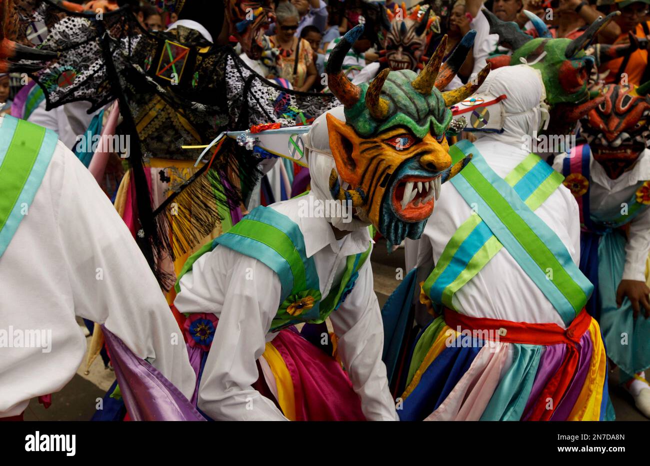 Dancers wearing a traditional devil mask and costumes dance during ...