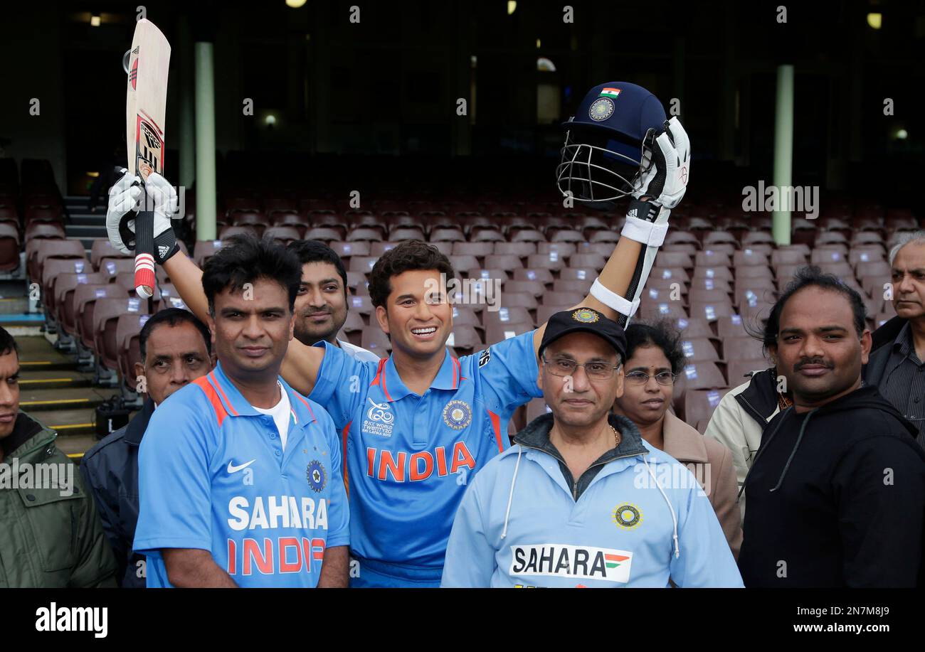 Indian cricket fans stand behind a wax statue of Indian cricketer ...