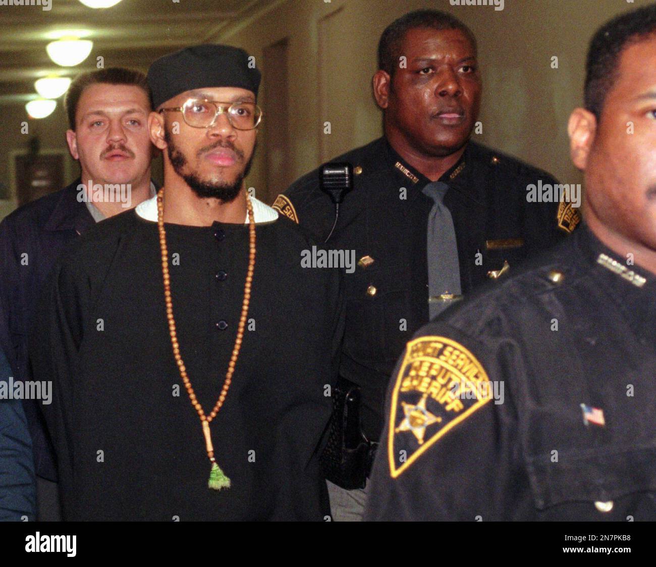 FILE - This Tuesday, Jan. 16, 1996 file photo shows Carlos Sanders, with cap, under heavy guard ...