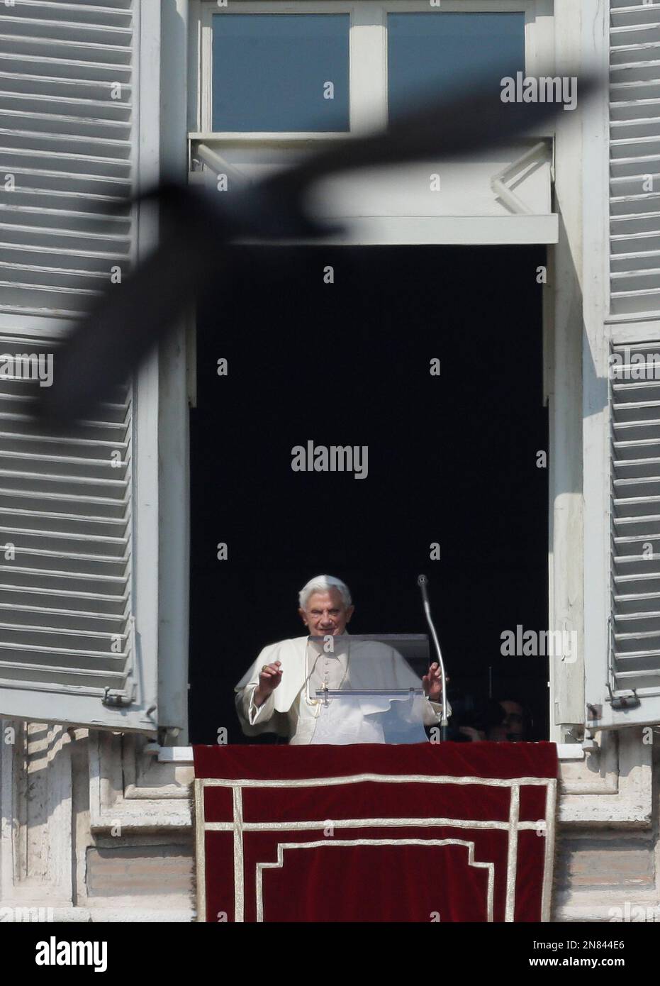 A pigeon flies in front of Pope Benedict XVI as he waves to the ...