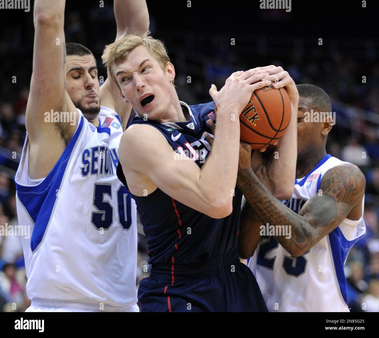 Connecticut's Niels Giffy, center, comes down with a rebound as he is ...