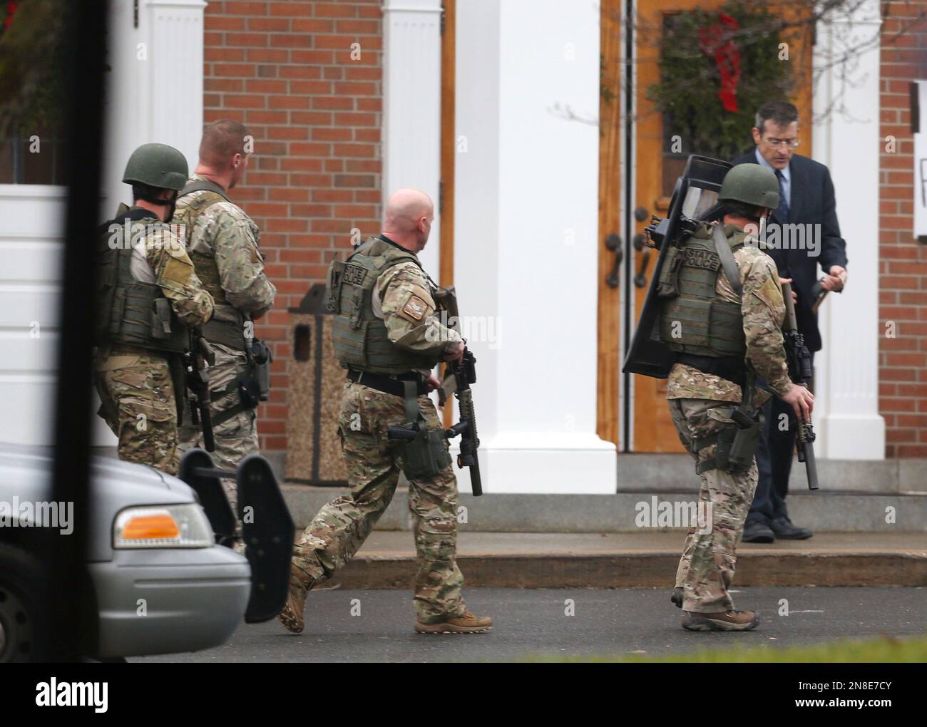 A Conn. State Police tactical team searches the area around St. Rose of ...