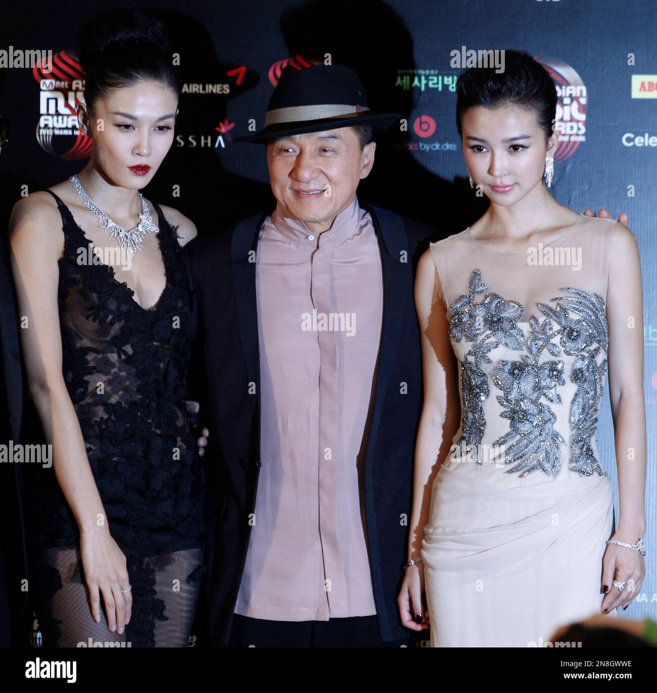 Hong Kong movie star Jackie Chan, center, poses with two Mainland ...