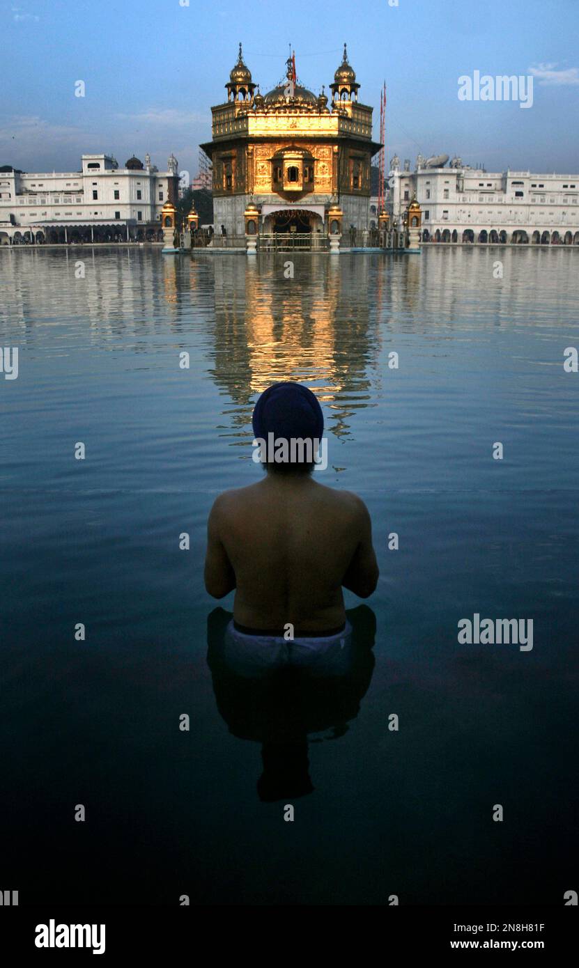 An Indian Sikh devotee takes a holy bath in the sacred pond of the ...