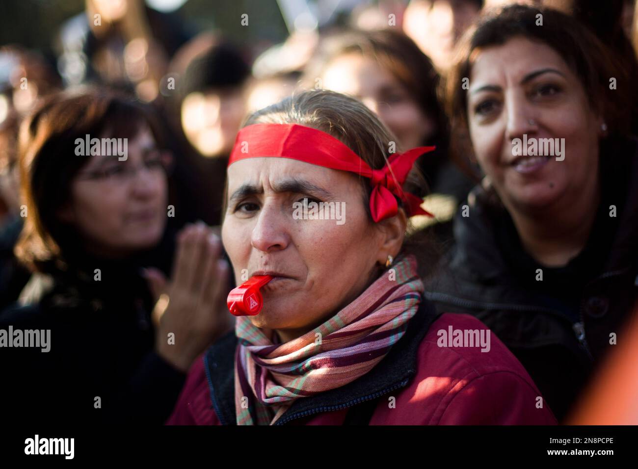 A woman blows a whistle during a demonstration of mostly Alevi people ...