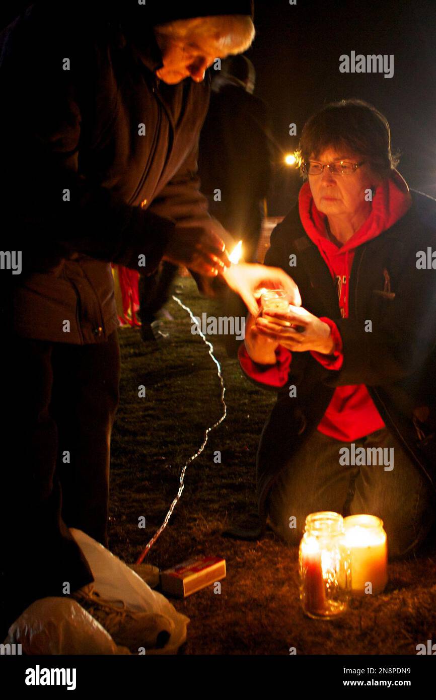 Leona Wieland, 65, of Sioux Falls, lights candles in peaceful protest ...