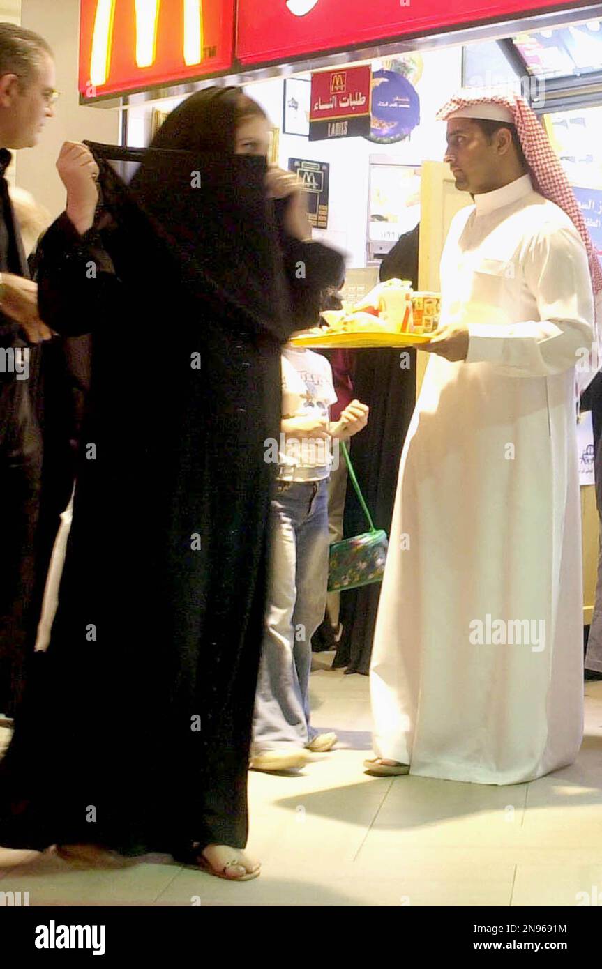 A Saudi woman adjusts her veil Friday, Oct. 31, 2003, in the food court ...