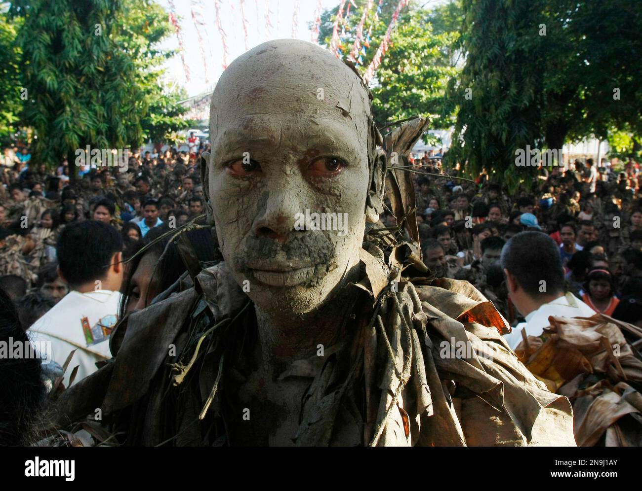 Filipino Catholic devotees, who soaked themselves in mud and wrapped in ...