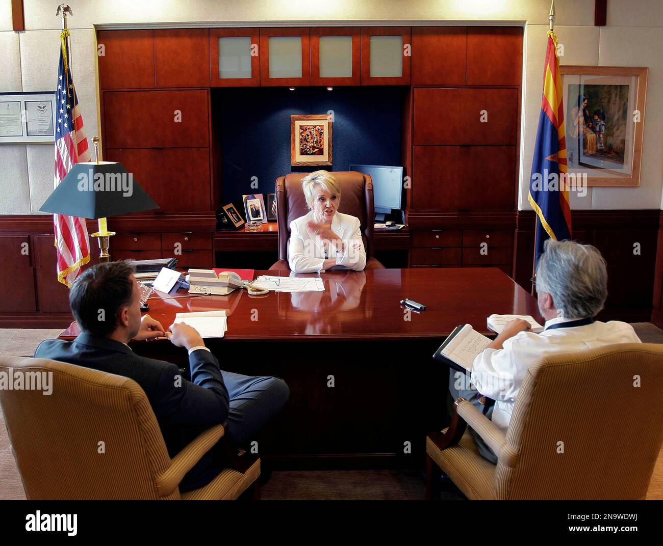 Arizona Gov. Jan Brewer, center, speaks during an interview from her ...
