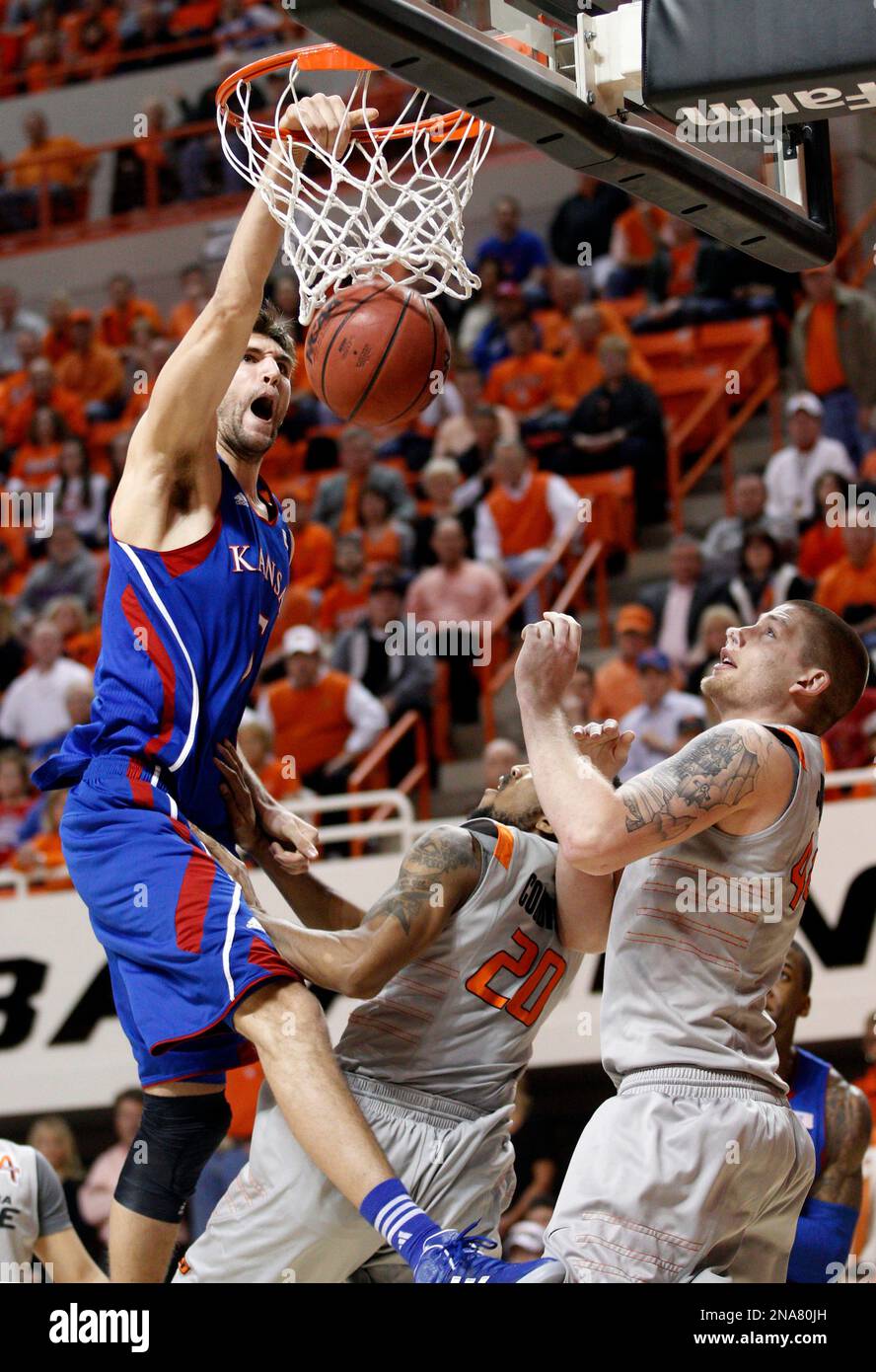 Kansas center Jeff Withey, left, dunks over Oklahoma State forward ...