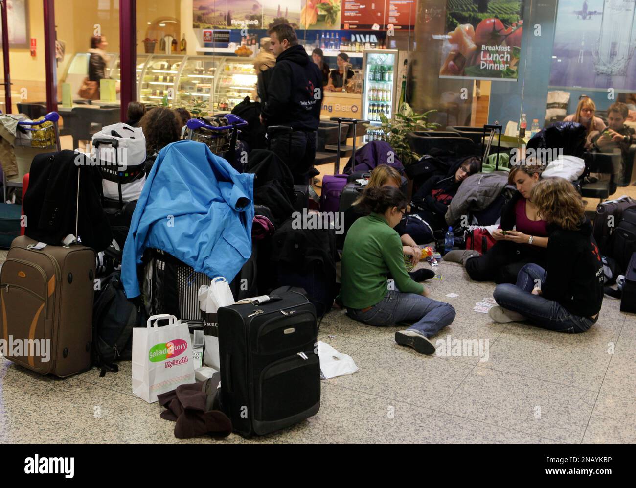 Passengers sit next to their luggage as flights were cancelled after a ...