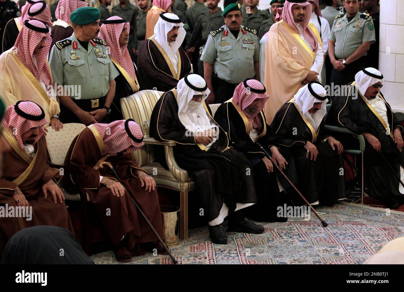 King Abdullah of Saudi Arabia, center, covers his face with a medical ...