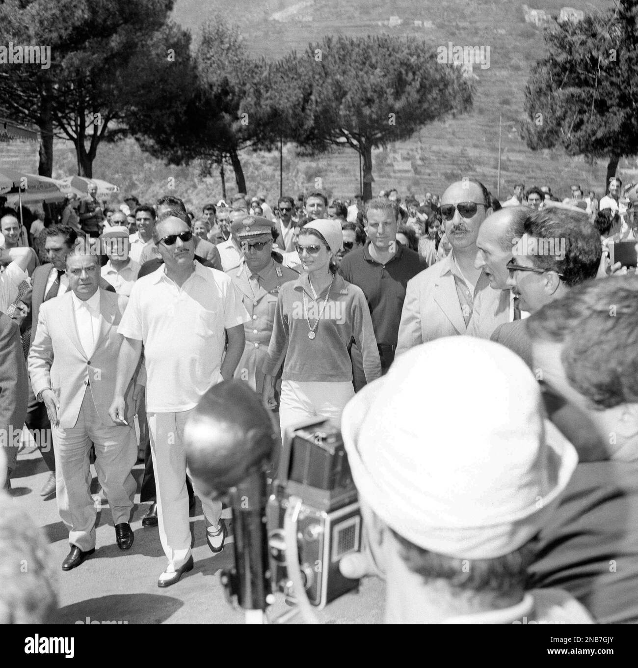 Mrs. Jacqueline Kennedy is surrounded by curious villagers as she ...