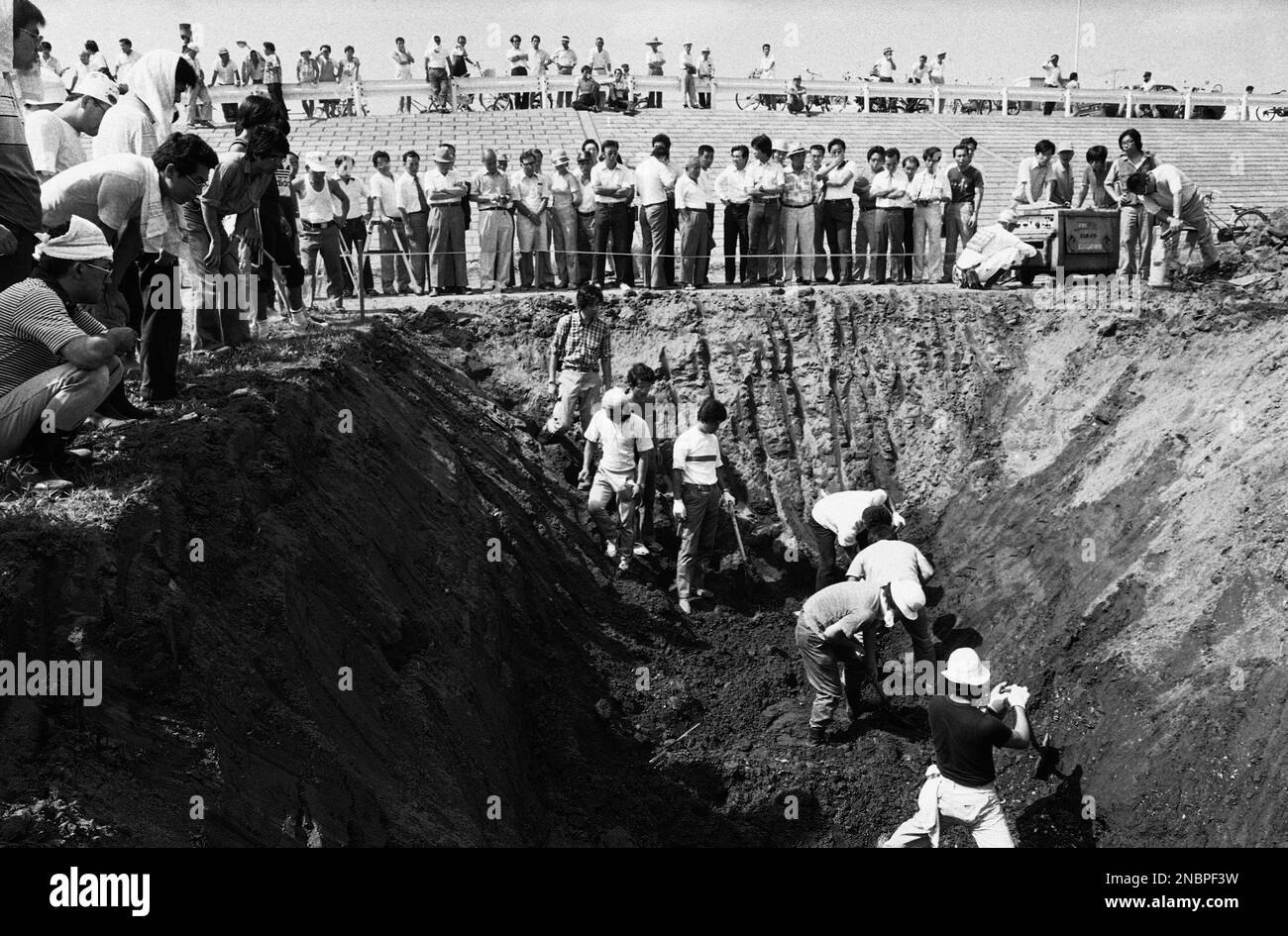 Workers excavate dry riverbed of the Arakawa River in Tokyo, Sept. 2 ...