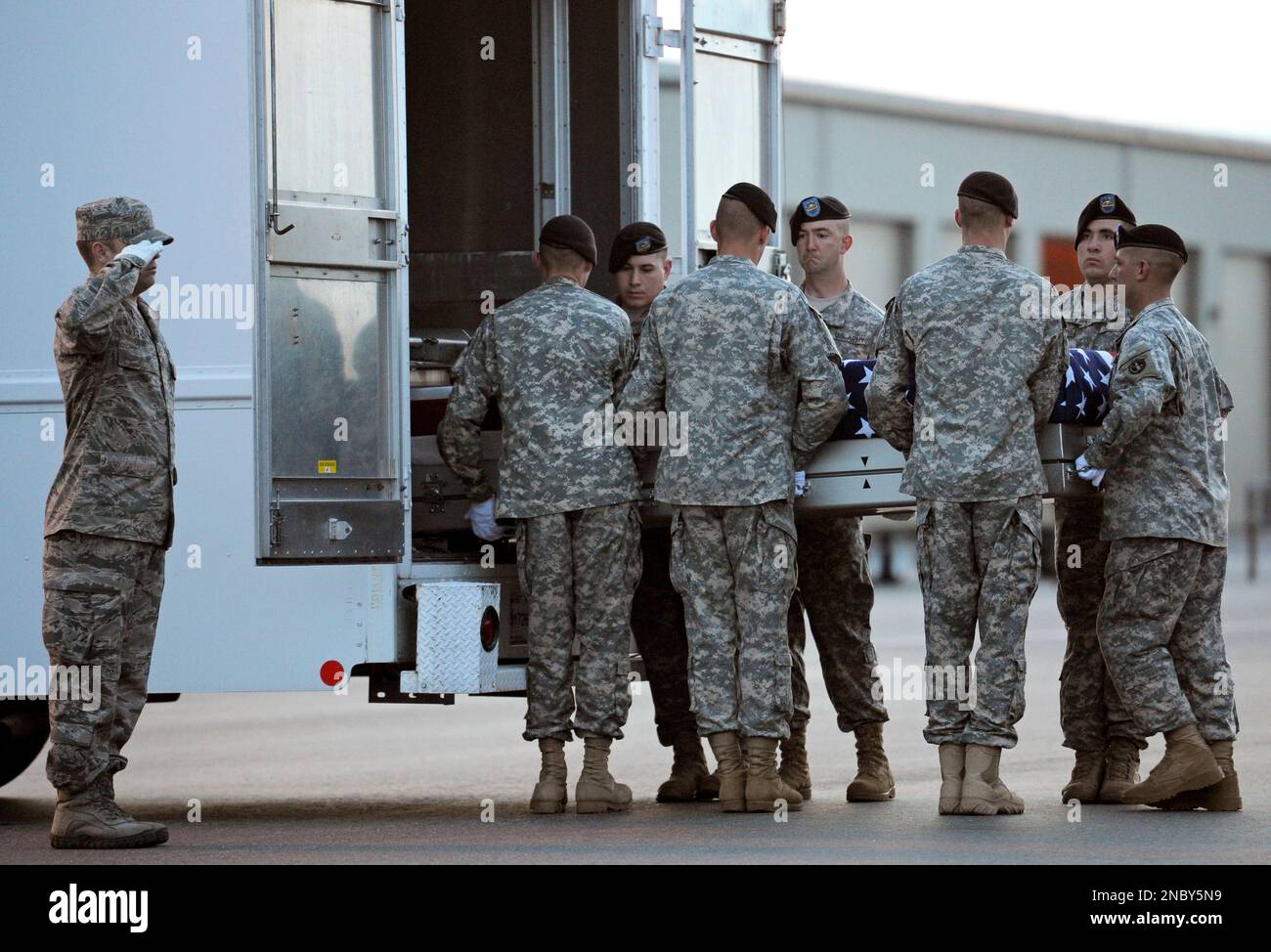An Army carry team places the transfer case containing the remains of ...