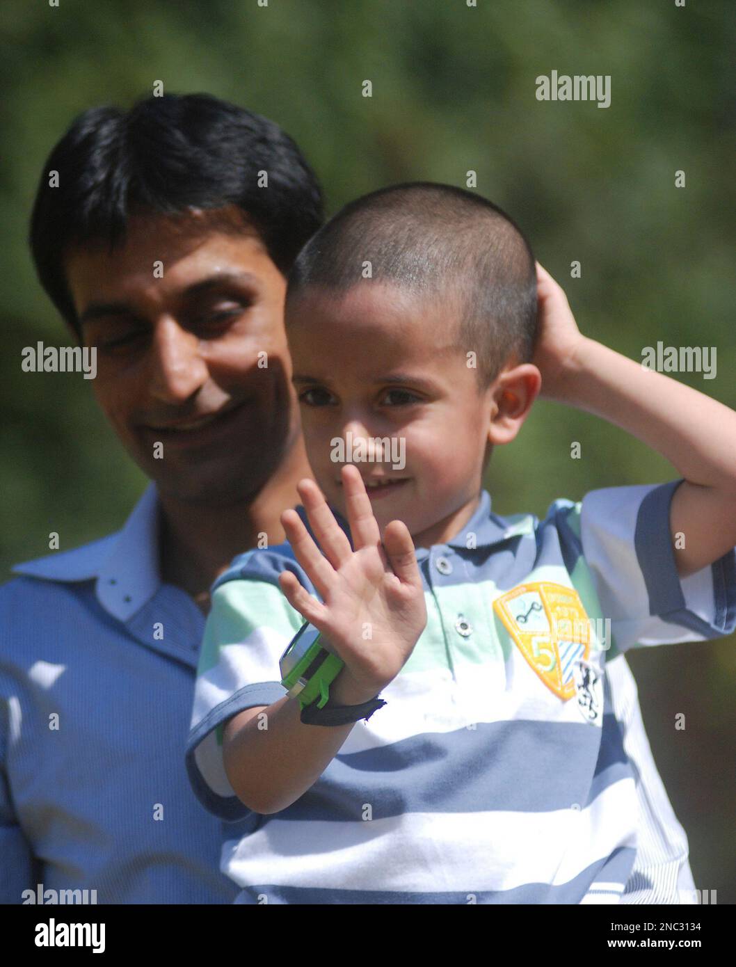 FILE - British child Sahil Saeed waves with his father Raja Naqqash ...