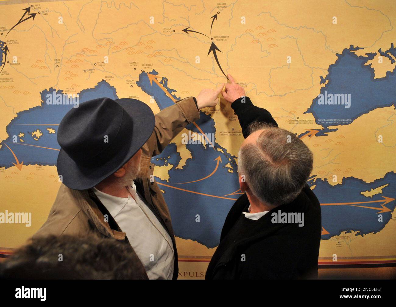 Visitors look at a map that displays the paths of expulsion of Jews ...