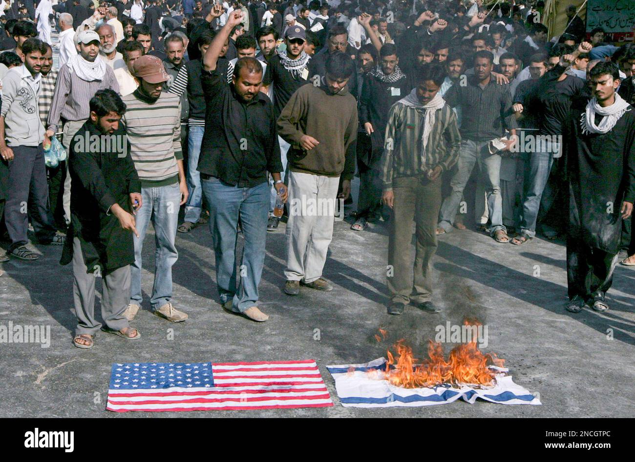 Pakistani Shiite Muslims burn Israeli, right, and U.S. flags during a ...