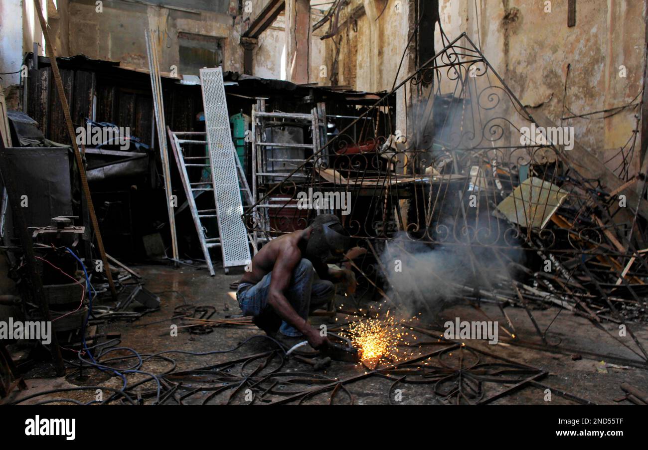 A worker welds iron in a workshop in Havana, Cuba, Thursday, Sept. 9 ...