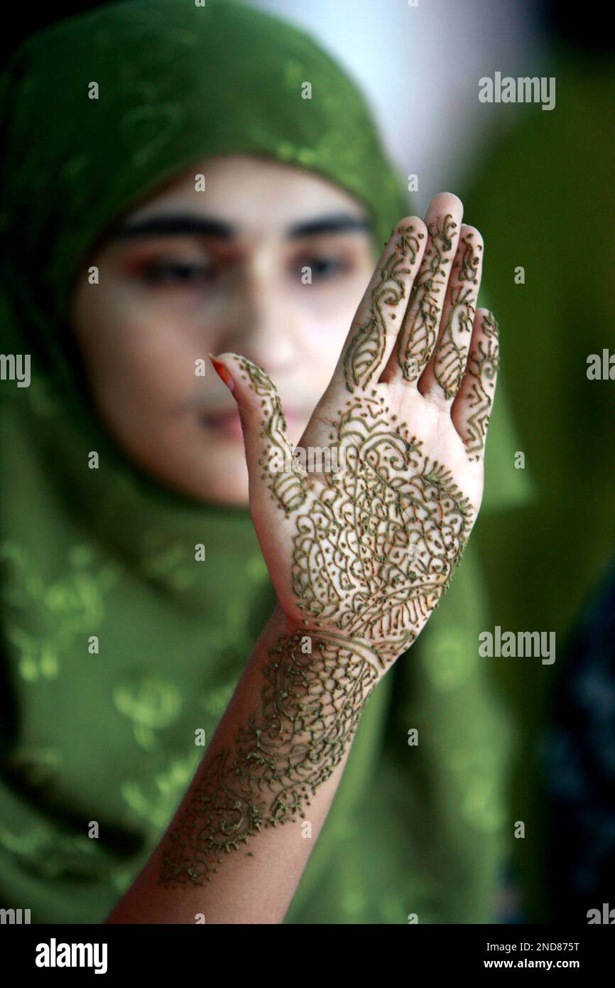 A Bangladeshi Muslim girl displays her henna-decorated hand during a ...
