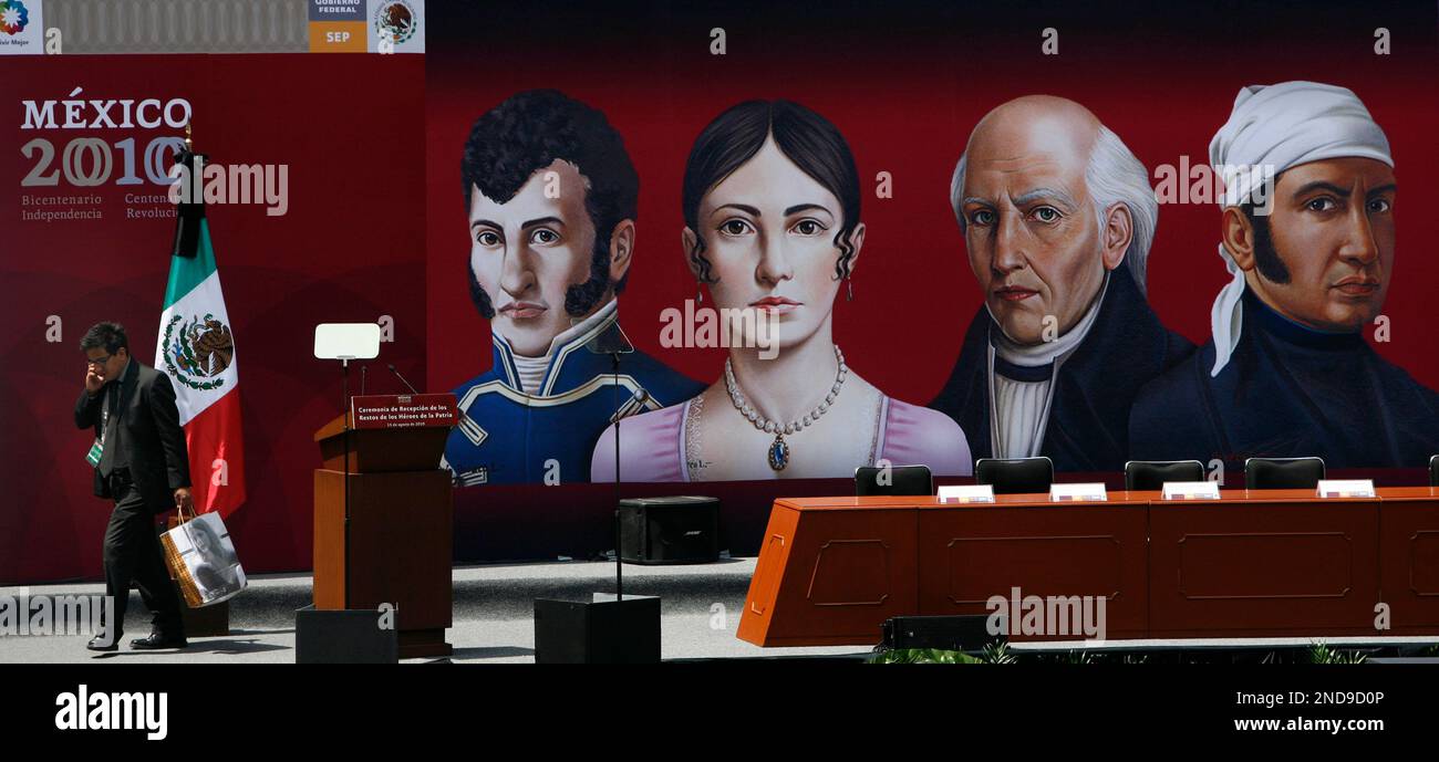 A man walks next to a mural depicting Mexico's national heroes, from ...
