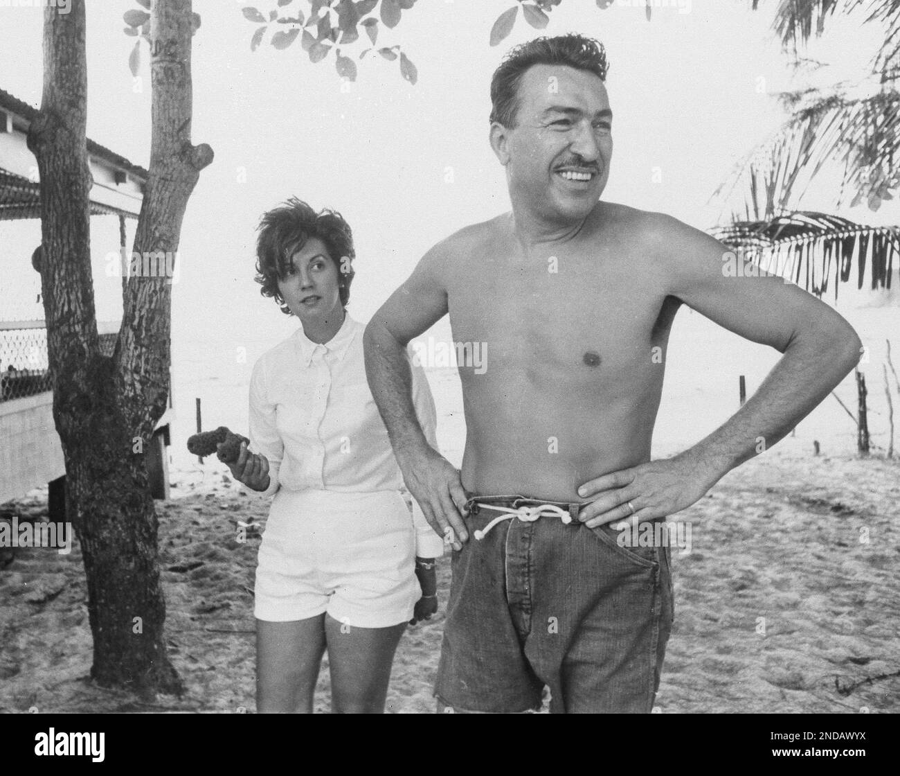 Stripped to the waist, Adam Clayton Powell, Jr., soaks up the sun he ...
